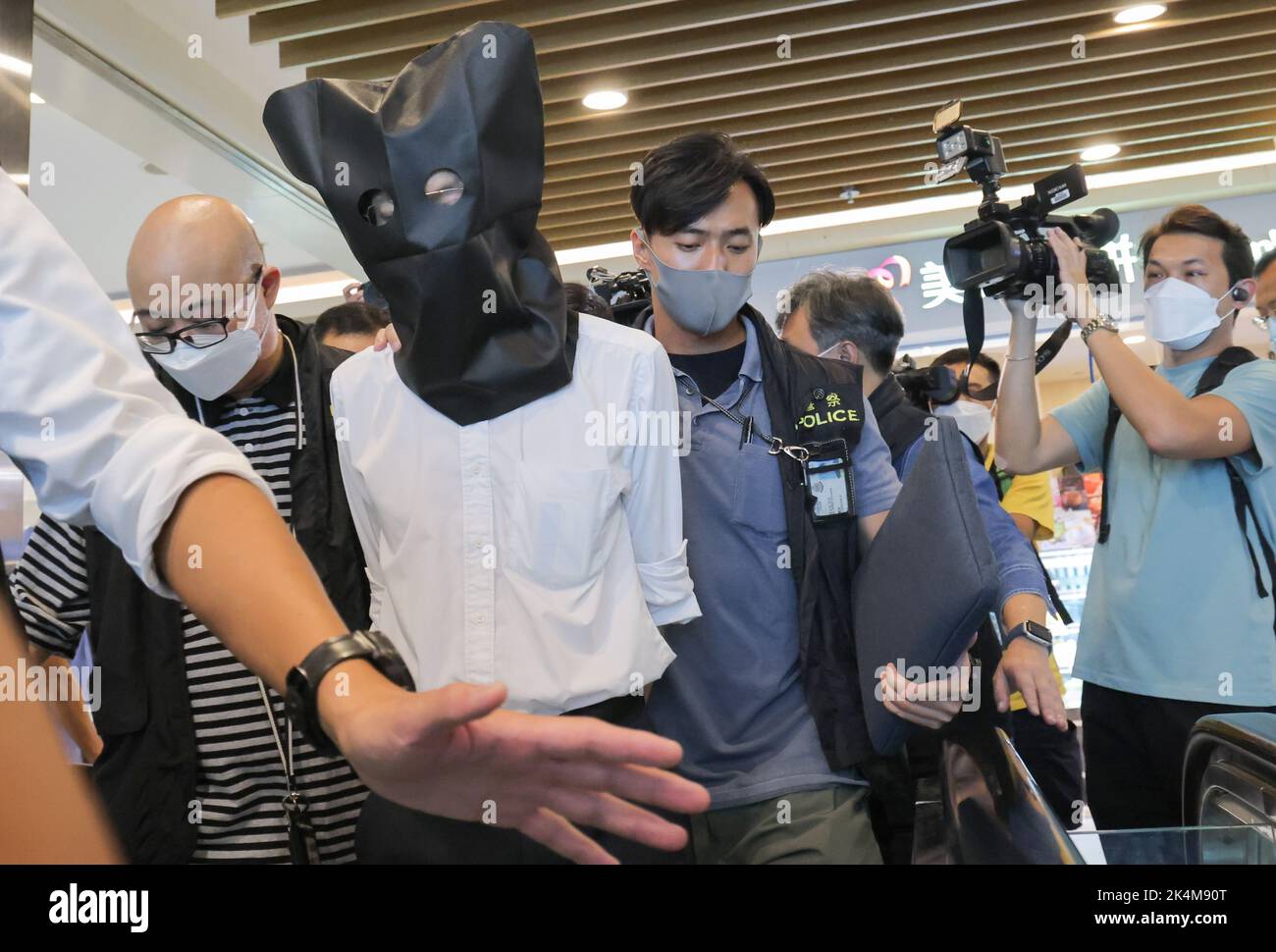 Police officers escort a suspect from the clinic of Doctor Wong Ping ...