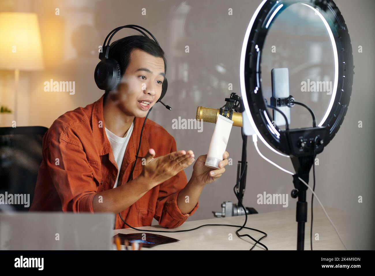 Modern young Asian male influencer sitting at desk in home studio ...