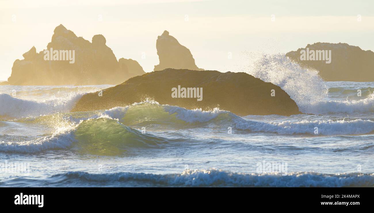 Backlit ocean seascape of waves and rock formations in the Pacific ...