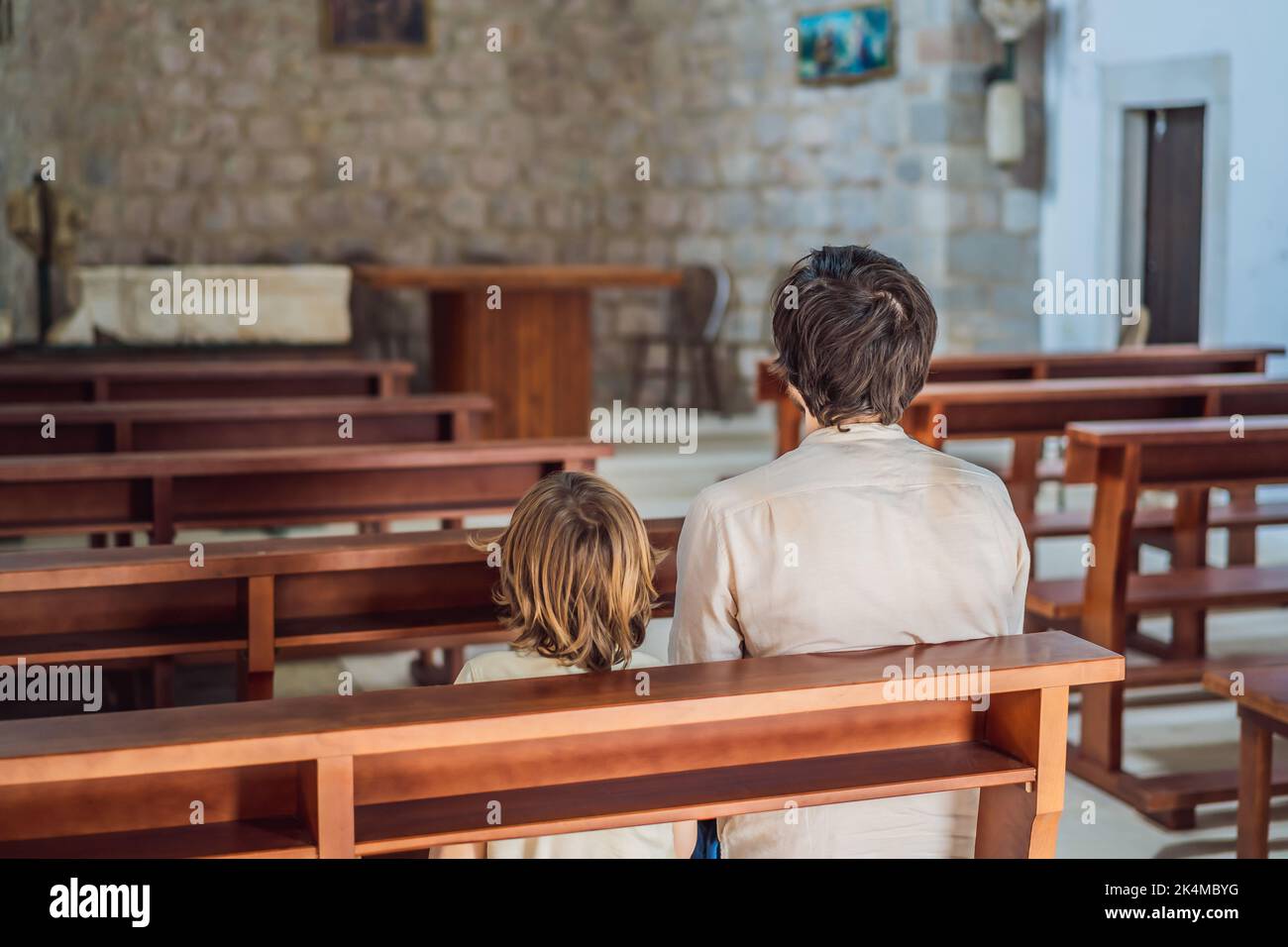 Christian dad tells his son Bible stories about Jesus sitting in kirk ...