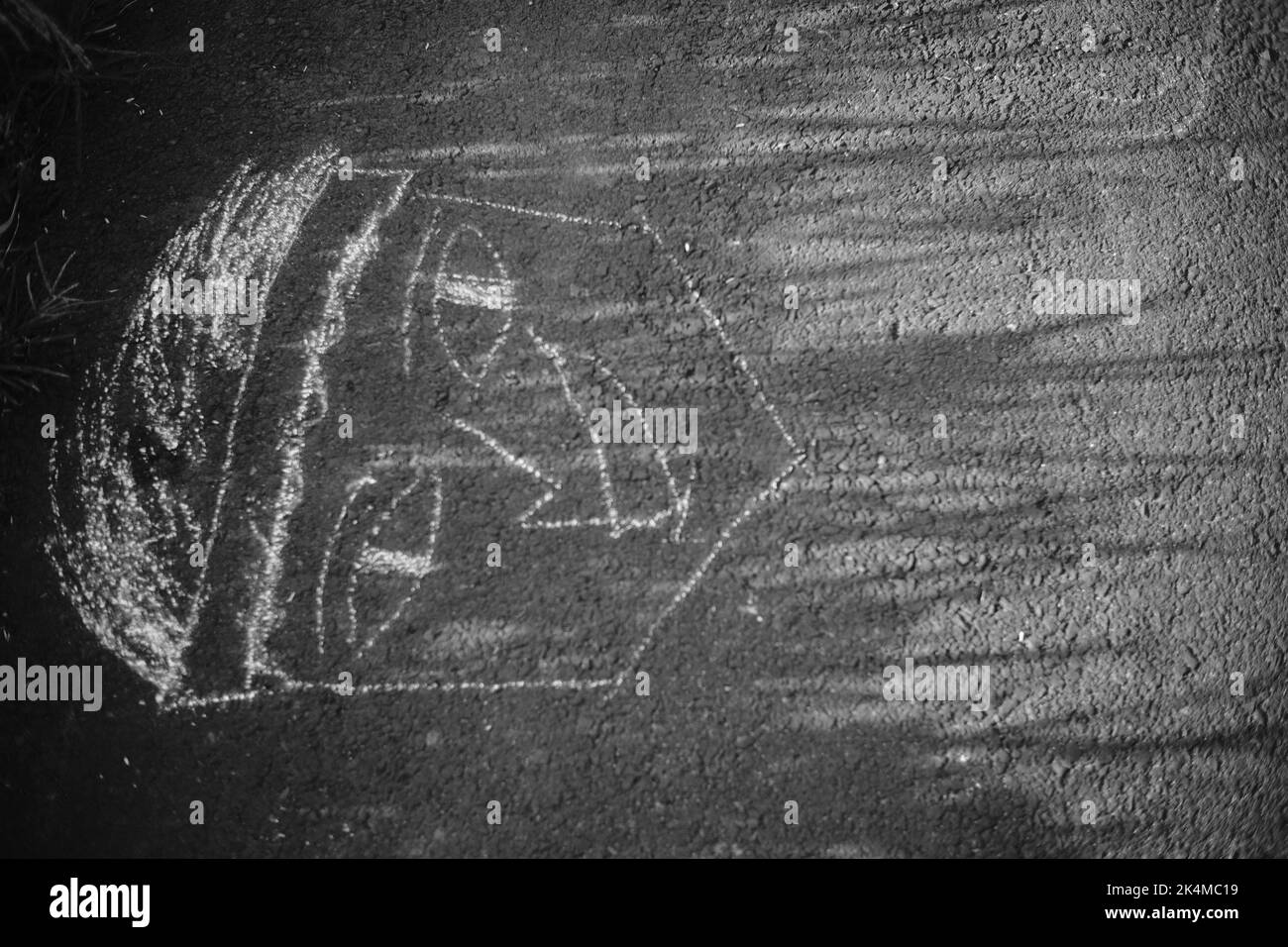 A chalk drawing, a monochrome photo of a face on asphalt with a rice ...