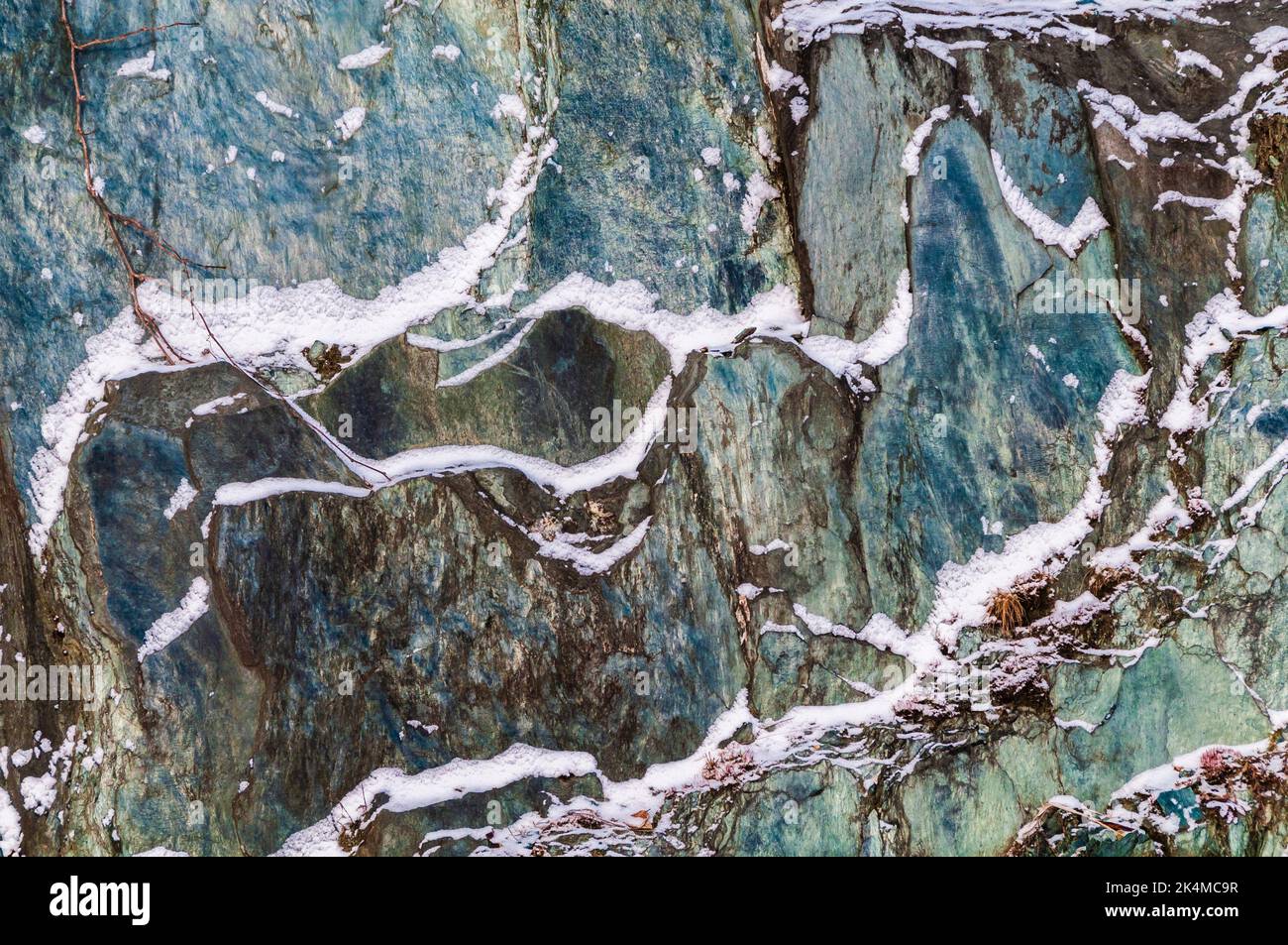 Colorful rock wall with snow on the ledges Stock Photo - Alamy