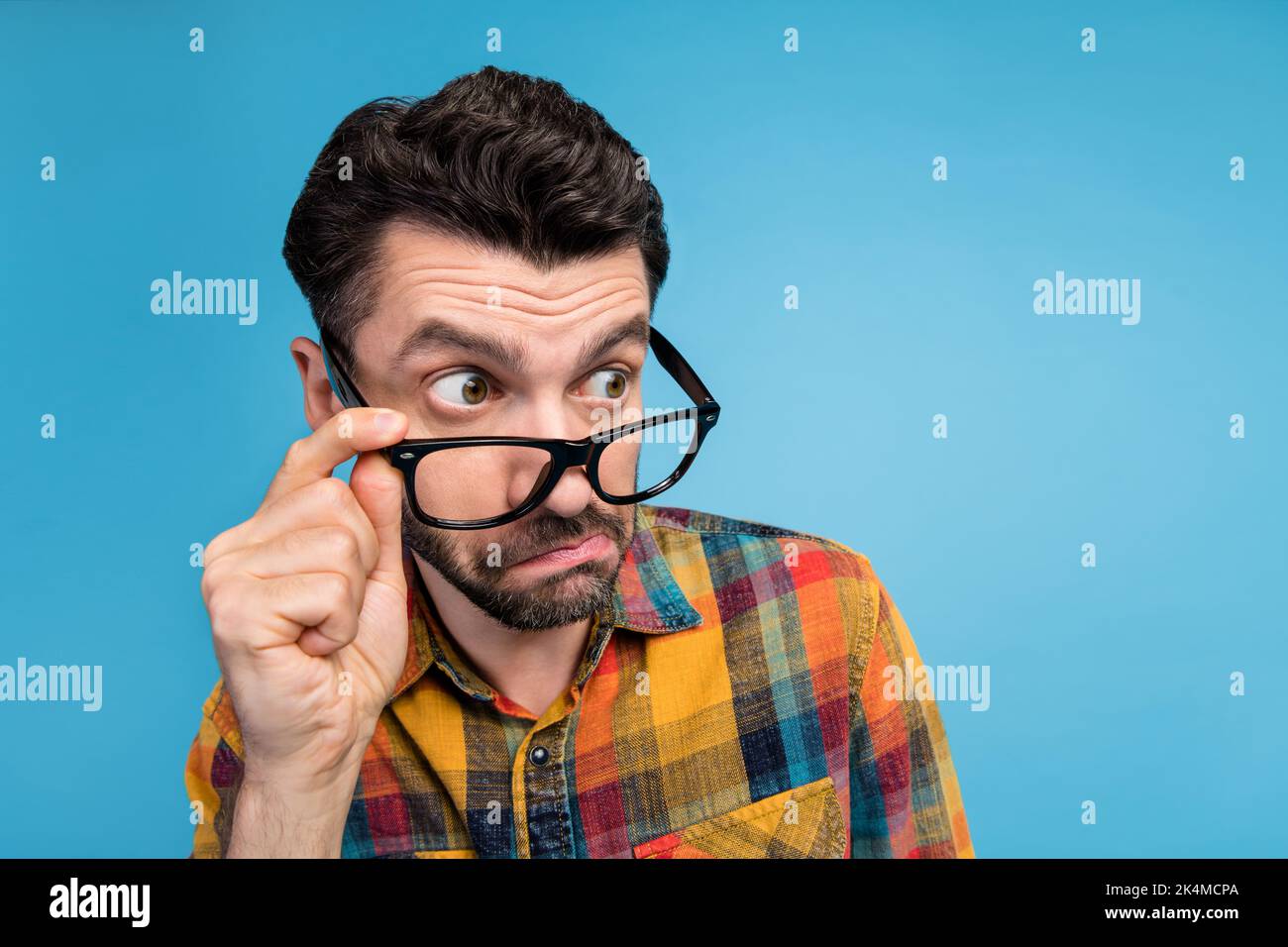 Photo of impressed handsome man dressed checkered shirt touching ...