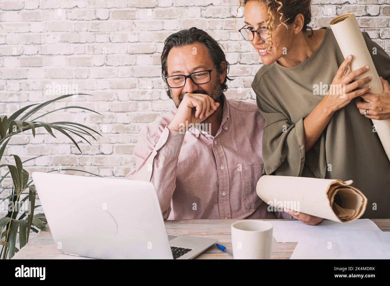 Man and woman team working happy together at the desk looking computer ...