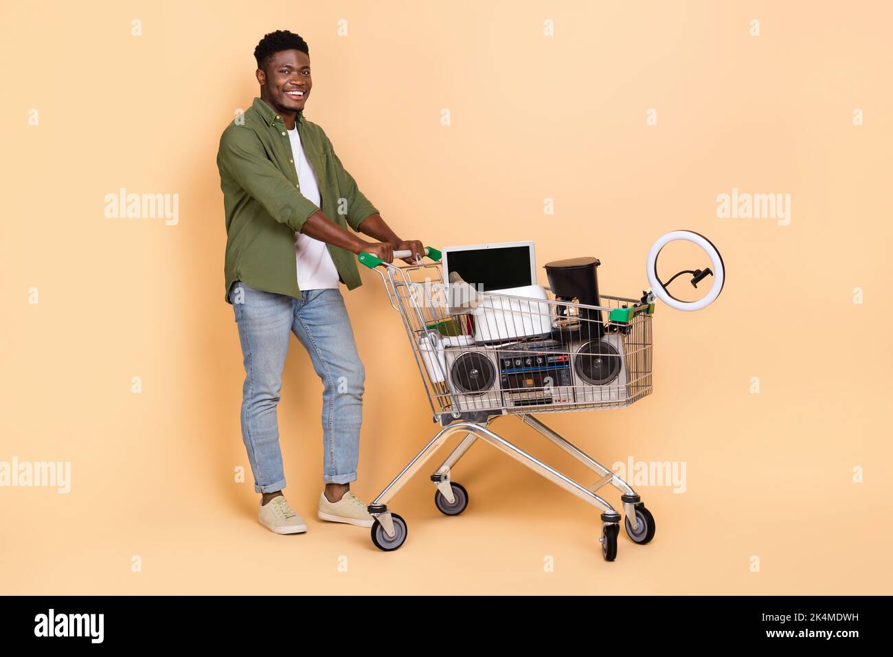 Photo of guy push cart have different items sell garage sale wear denim ...