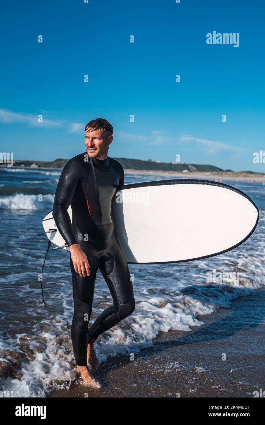 Man coming out of the sea after an afternoon doing his favorite sport ...