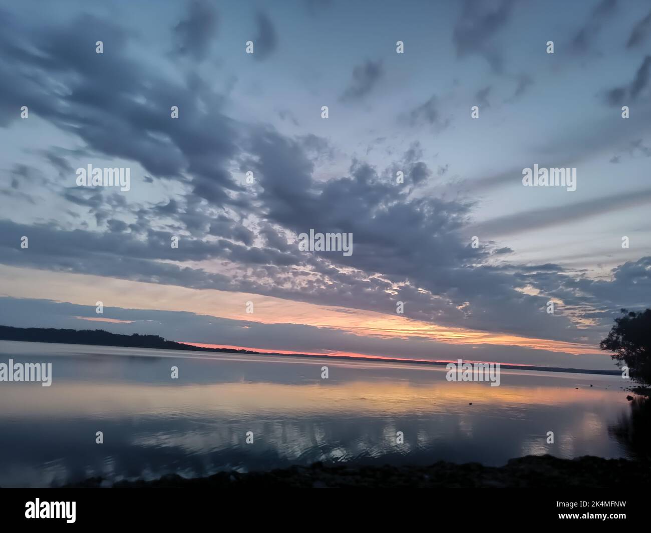 A beautiful sunset reflected on the water of a lake Stock Photo - Alamy