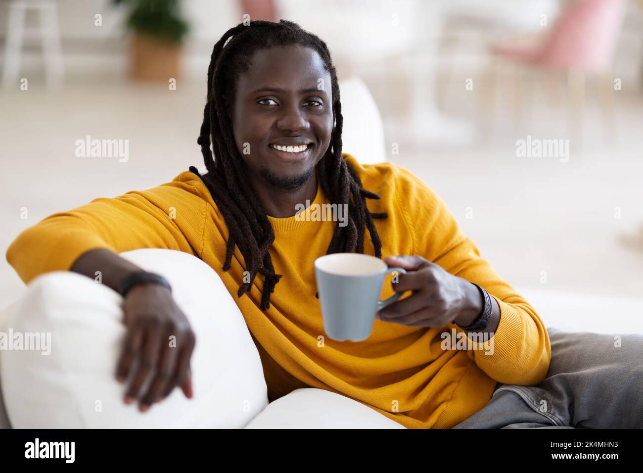 Domestic Pastime. Young Black Man Relaxing On Couch With Cup Of Coffee ...