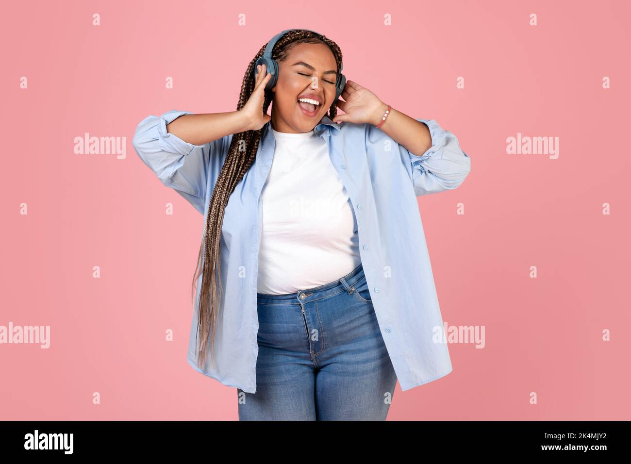 Happy Black Plus Size Woman Singing Wearing Headphones, Pink Background ...