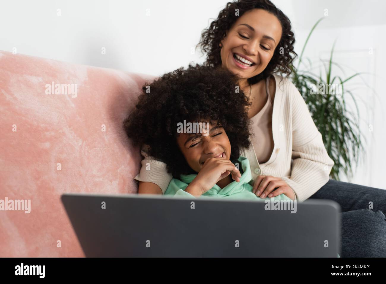 happy african american mother and daughter watching comedy movie on laptop,stock image Stock ...
