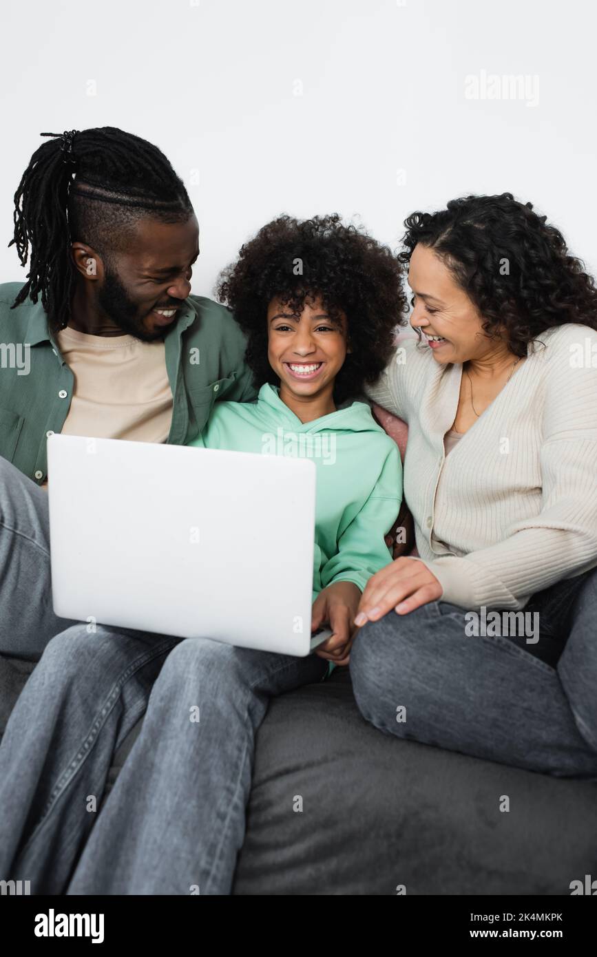 cheerful african american parents looking at preteen daughter with ...