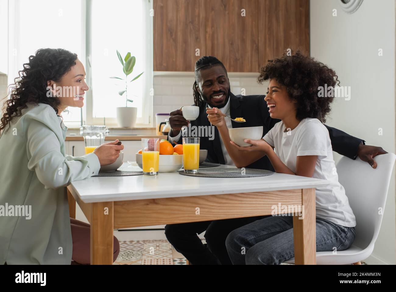 cheerful african american parents smiling and looking at preteen ...