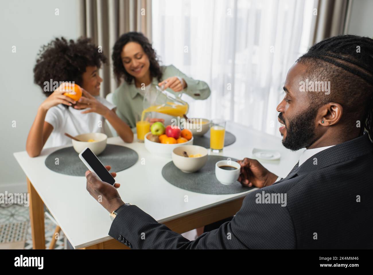 african american man in suit using smartphone with blank screen during ...