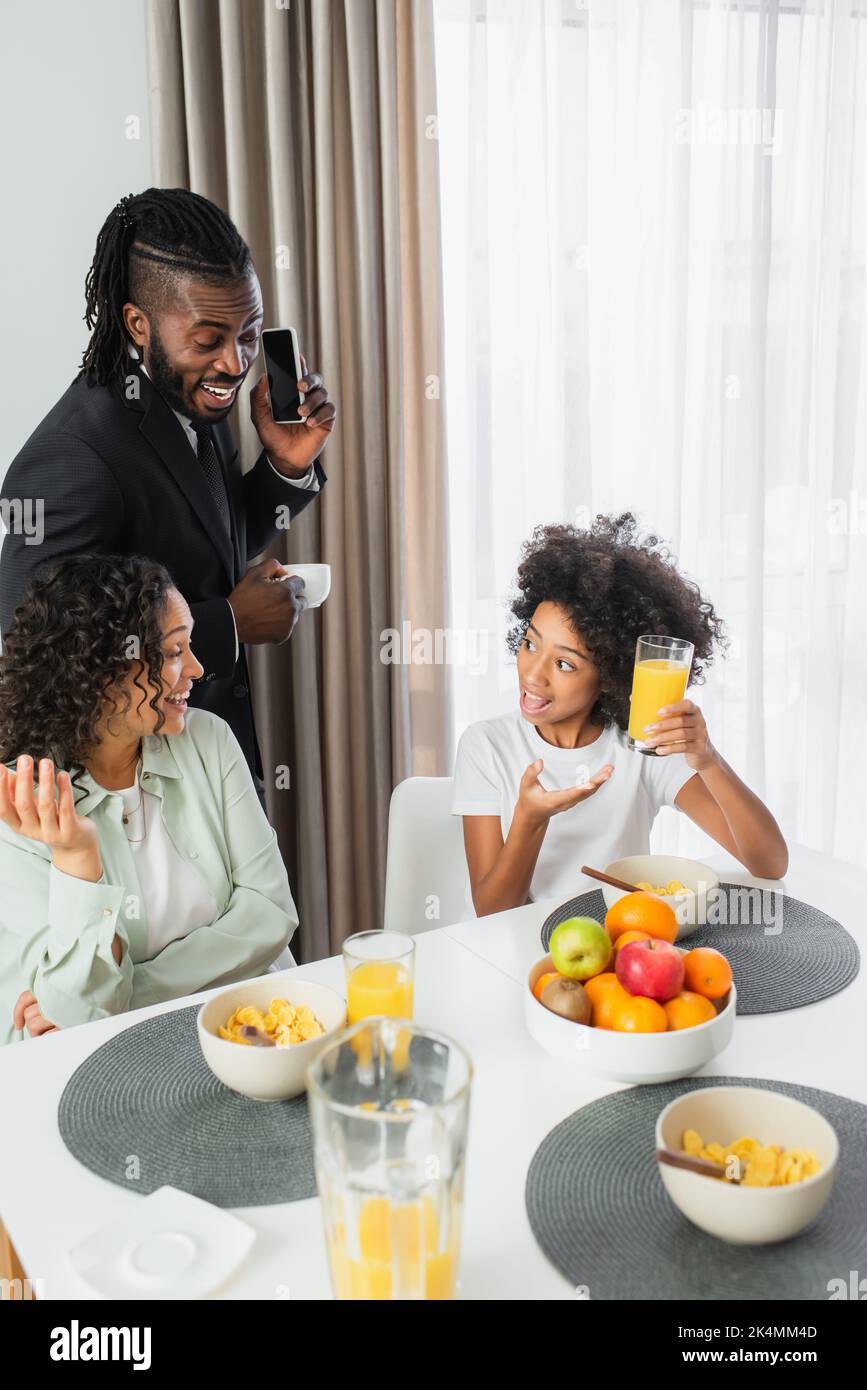 amazed african american girl pointing at glass of orange juice near ...