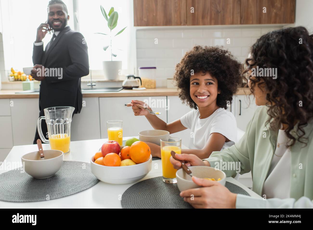 happy african american mother and daughter having breakfast near ...