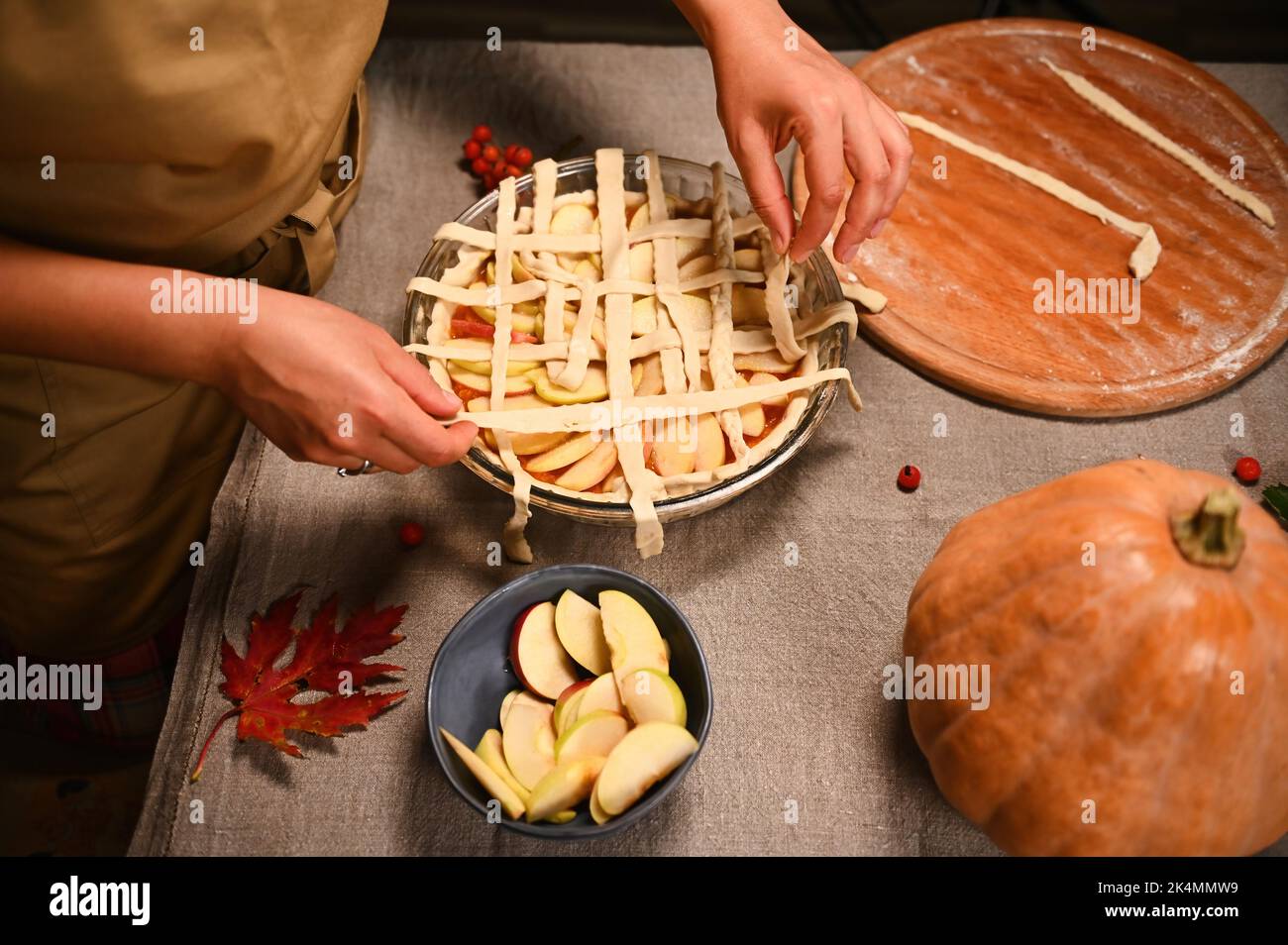 Overhead view. Housewife making crusty lattice from pastry stripes, on ...