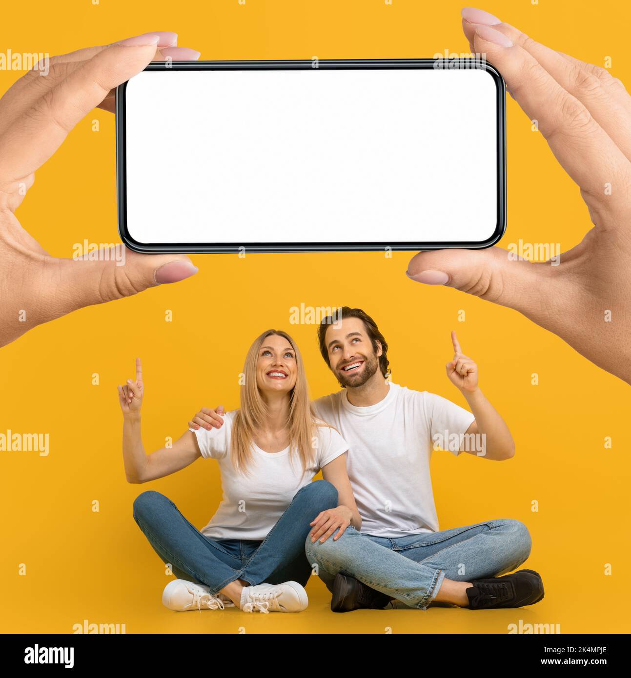 Happy millennial european woman and man point fingers at huge ...