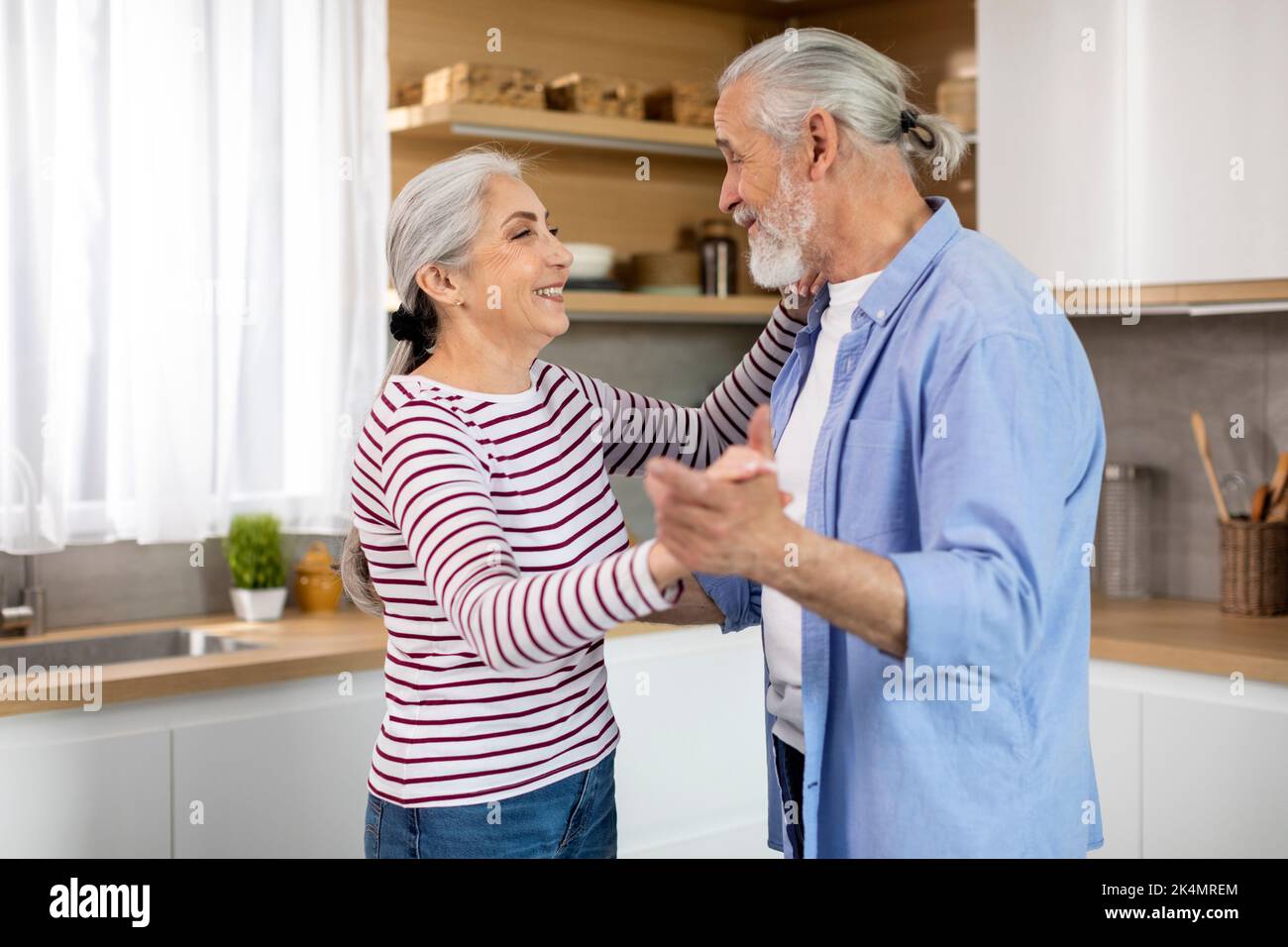 Happy Spouses. Loving Senior Husband And Wife Dancing In Kitchen ...