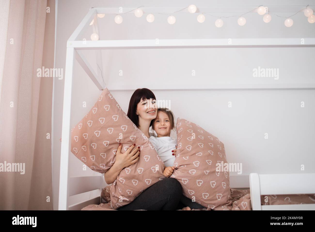 Satisfied caucasian young lady embracing preschooler girl after ...