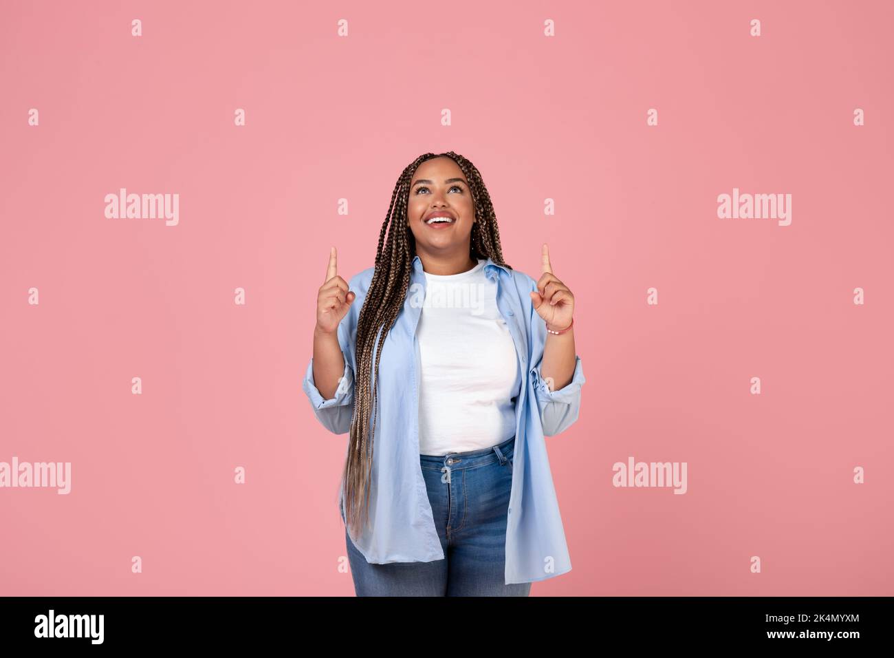 Cheerful African American Obese Woman Pointing Fingers Upward, Pink ...