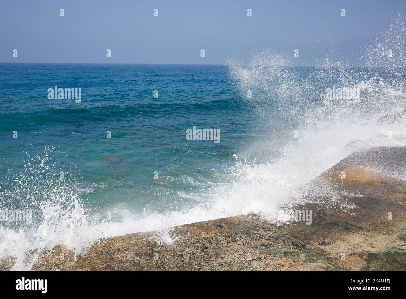 Sea water beats against rocky rocks and makes waves with foam Stock ...