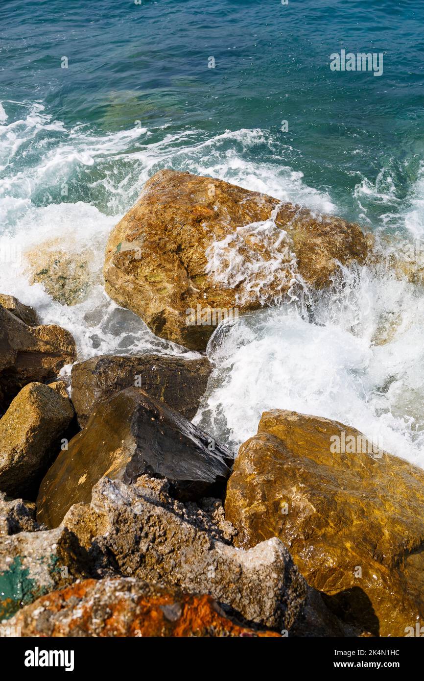Sea water beats against rocky rocks and makes waves with foam Stock ...