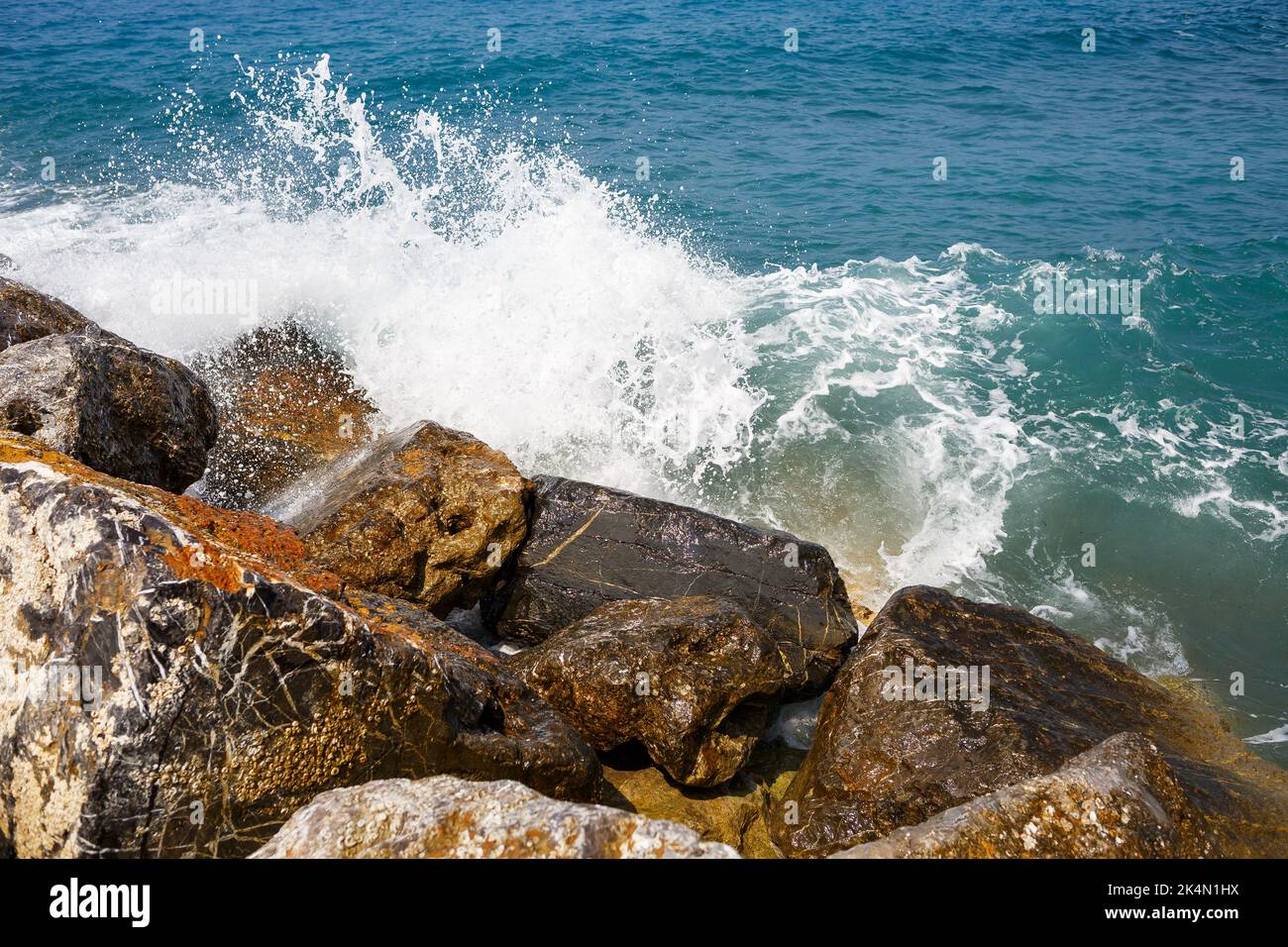 Sea water beats against rocky rocks and makes waves with foam Stock ...