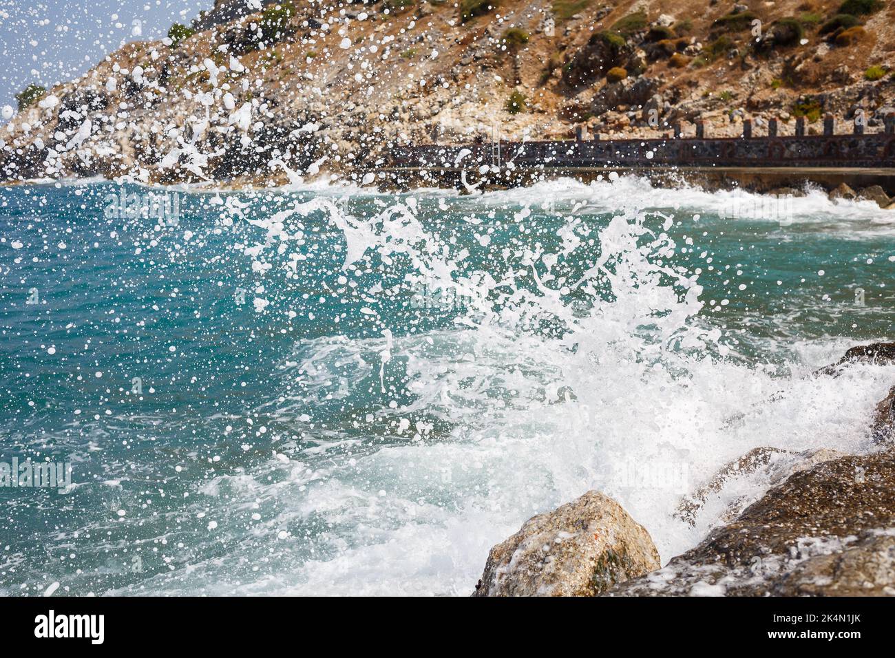 Sea water beats against rocky rocks and makes waves with foam, rugged ...