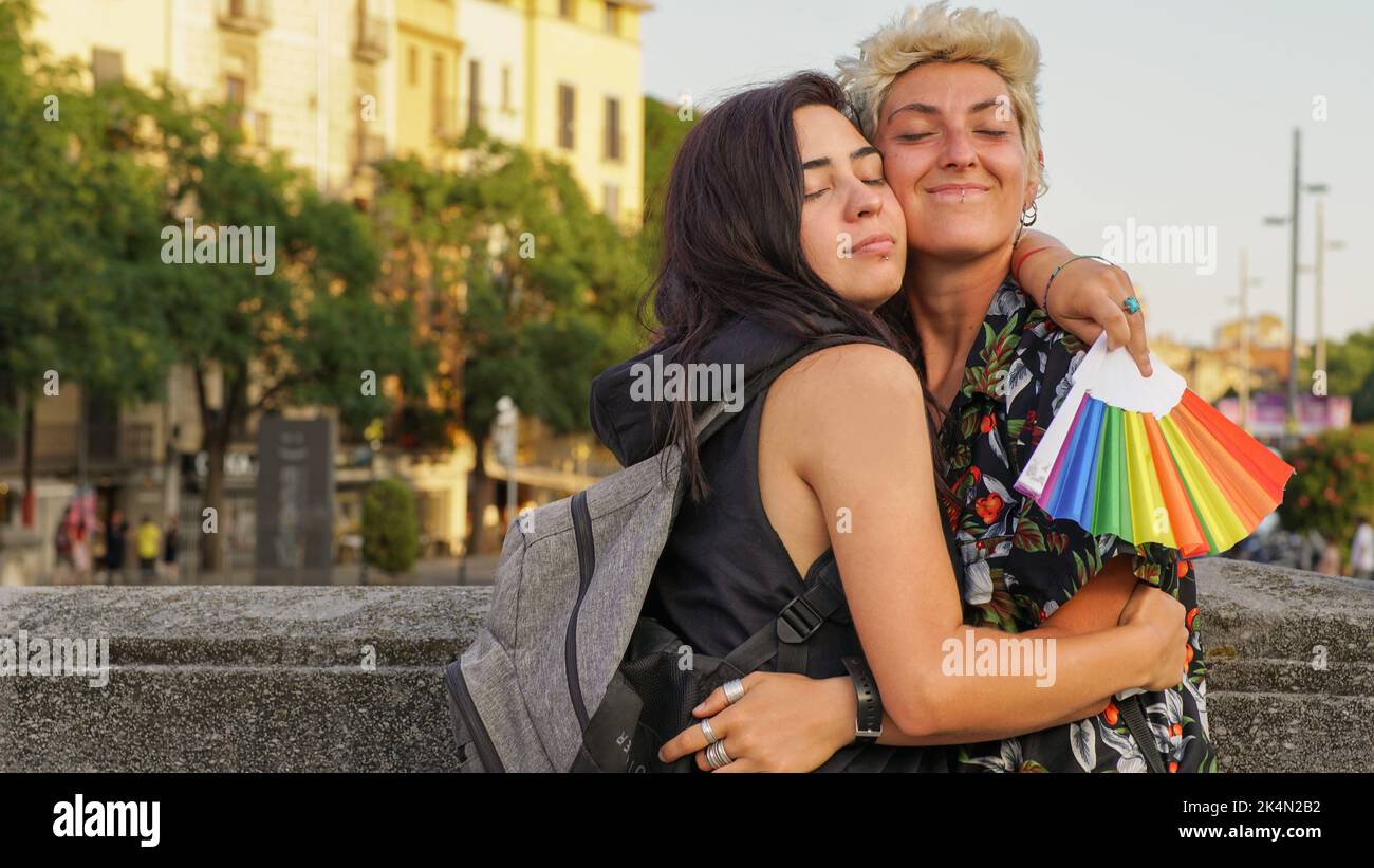 Two genderless people hug each other in the street Stock Photo - Alamy