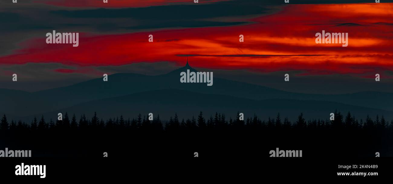 Red cloudy dark sunset near Jested hill over Liberec town in summer ...