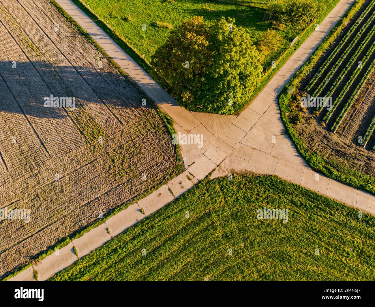 Several dirt roads seen with the drone meet at a fork in the road and ...