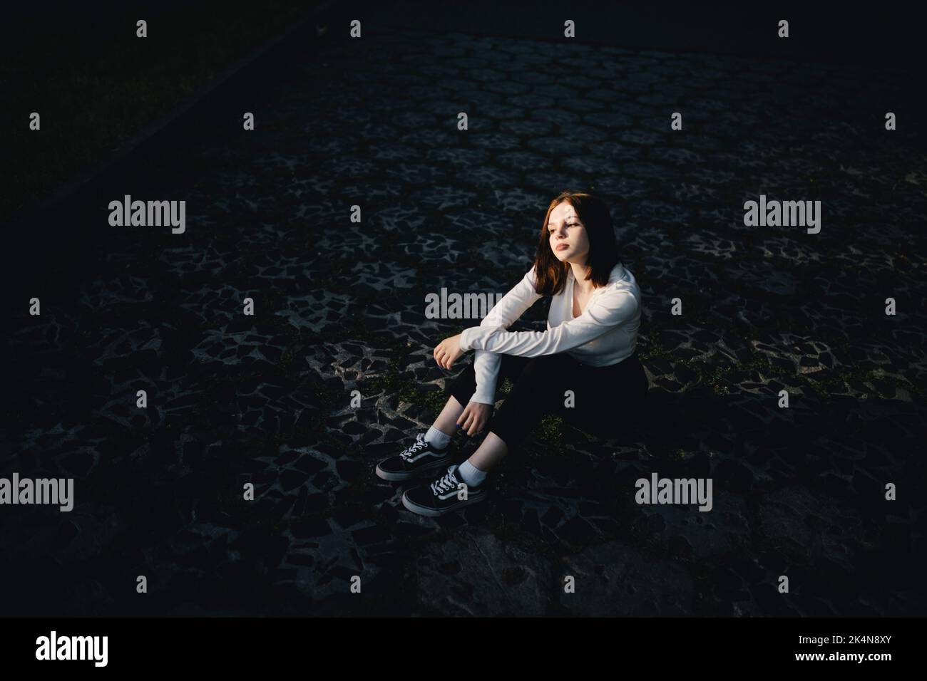 urban lonely girl sitting on the pavement Stock Photo - Alamy
