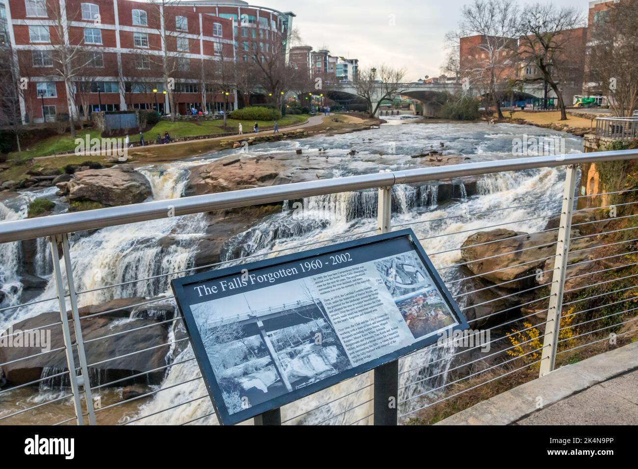 A unique pedestrian bridge that curves around a waterfall in Gre Stock ...