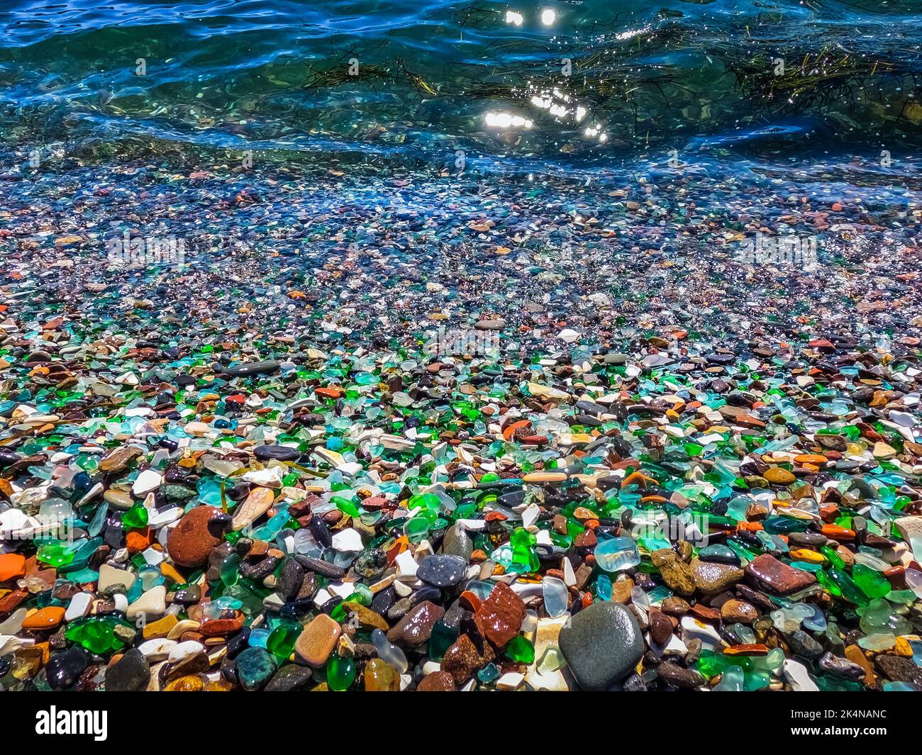 Natural polish textured sea glass and stones on the seashore. Azure ...
