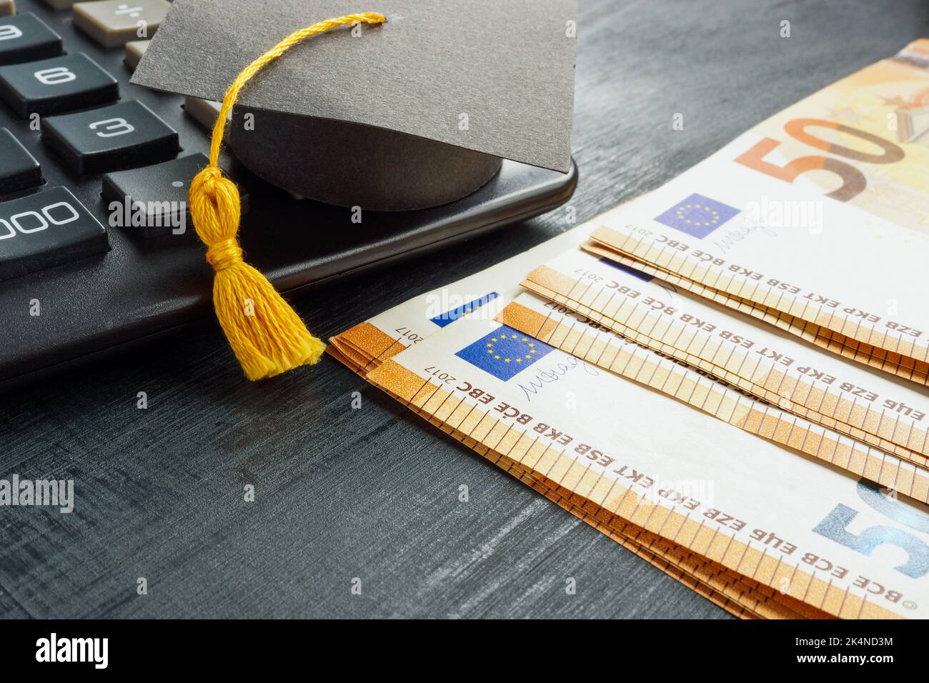 A graduate cap on a calculator and a euro as a symbol of tuition fees ...