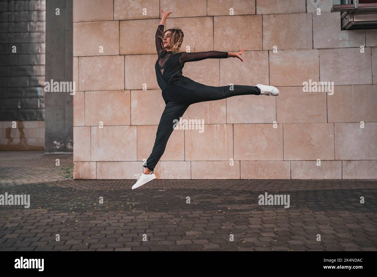 Young girl doing gymnastic jump on the street Stock Photo - Alamy