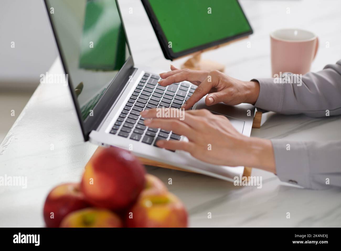 Side view of hands of young webdesigner pressing keys of laptop keypad ...