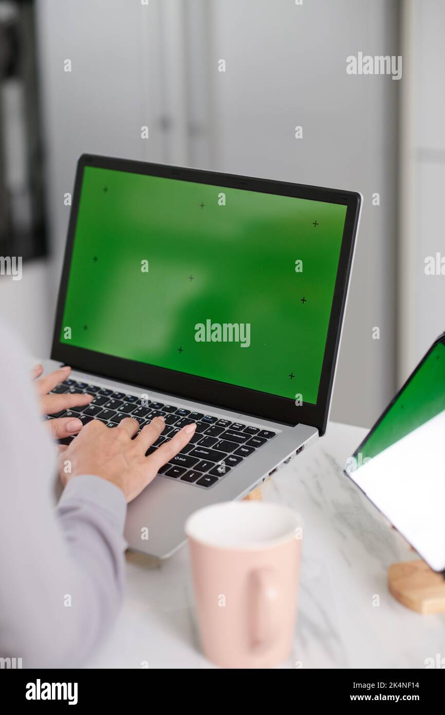 Hands of young female website designer working in front of green screen ...