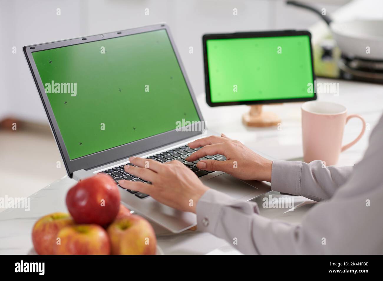 Hands Of Young Woman Typing On Keypad Of Laptop While Sitting By Kitchen Table At Home And
