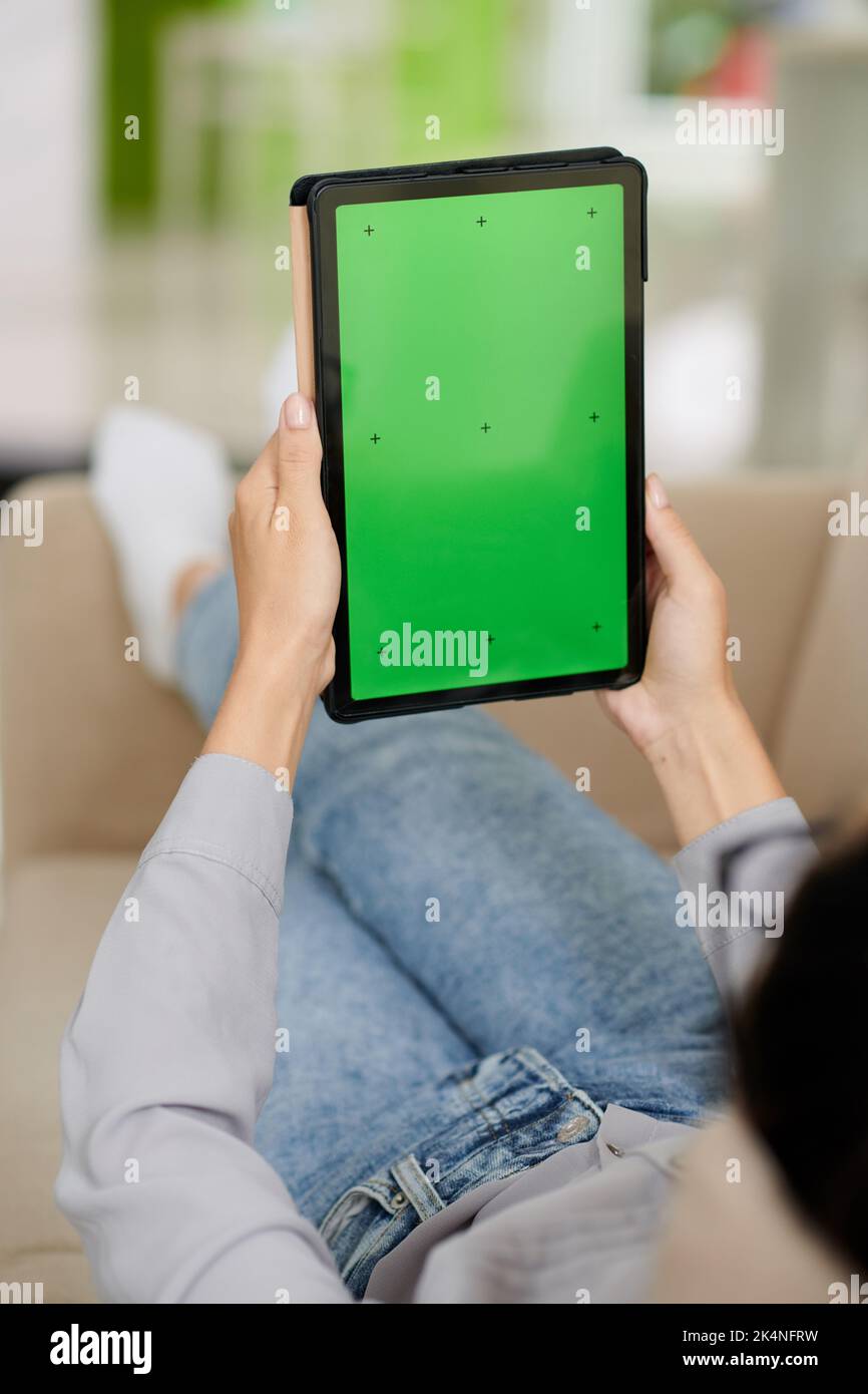 Digital tablet with blank green screen in hands of young restful woman ...