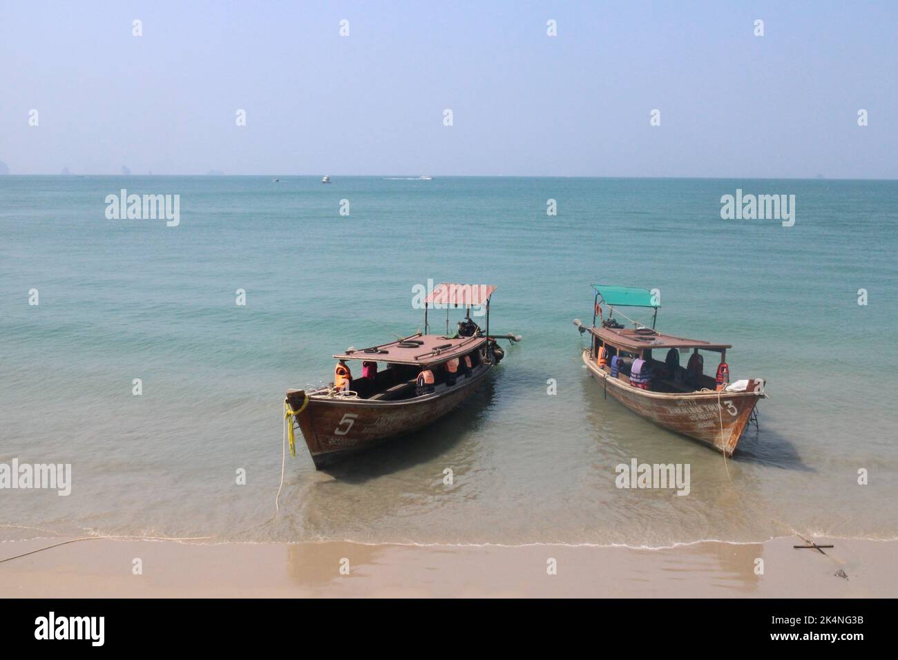 A high-angle shot of long-tail boats on a beach of Koh Jum, Thailand ...