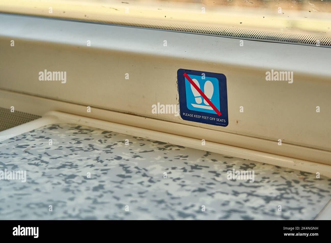 A sign indicating for passengers to keep their feet off of the seats ...