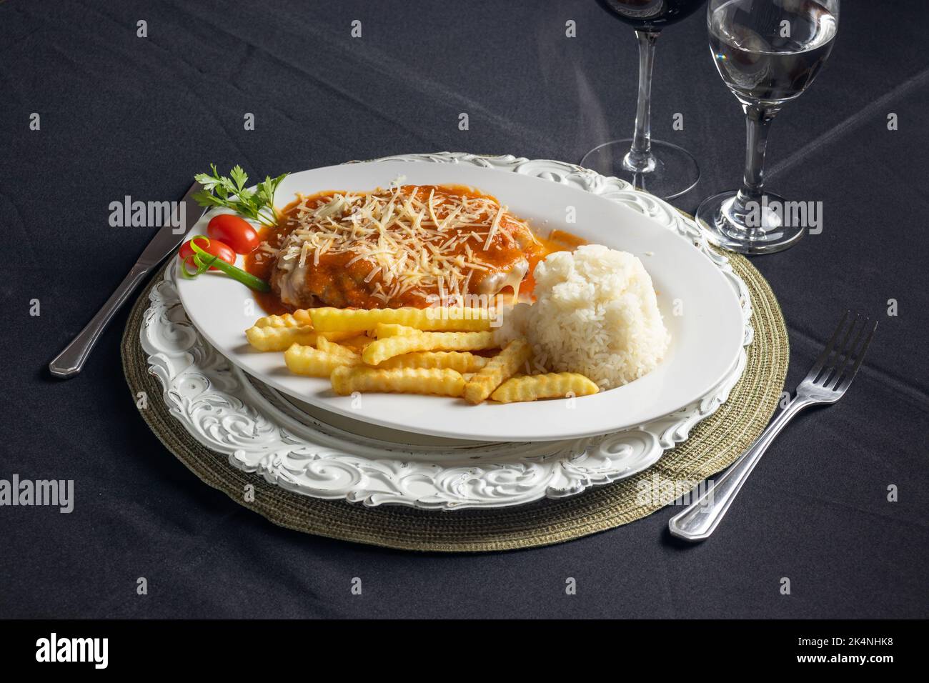A close-up shot of a rice dish, french fries, and chicken fillet on a ...