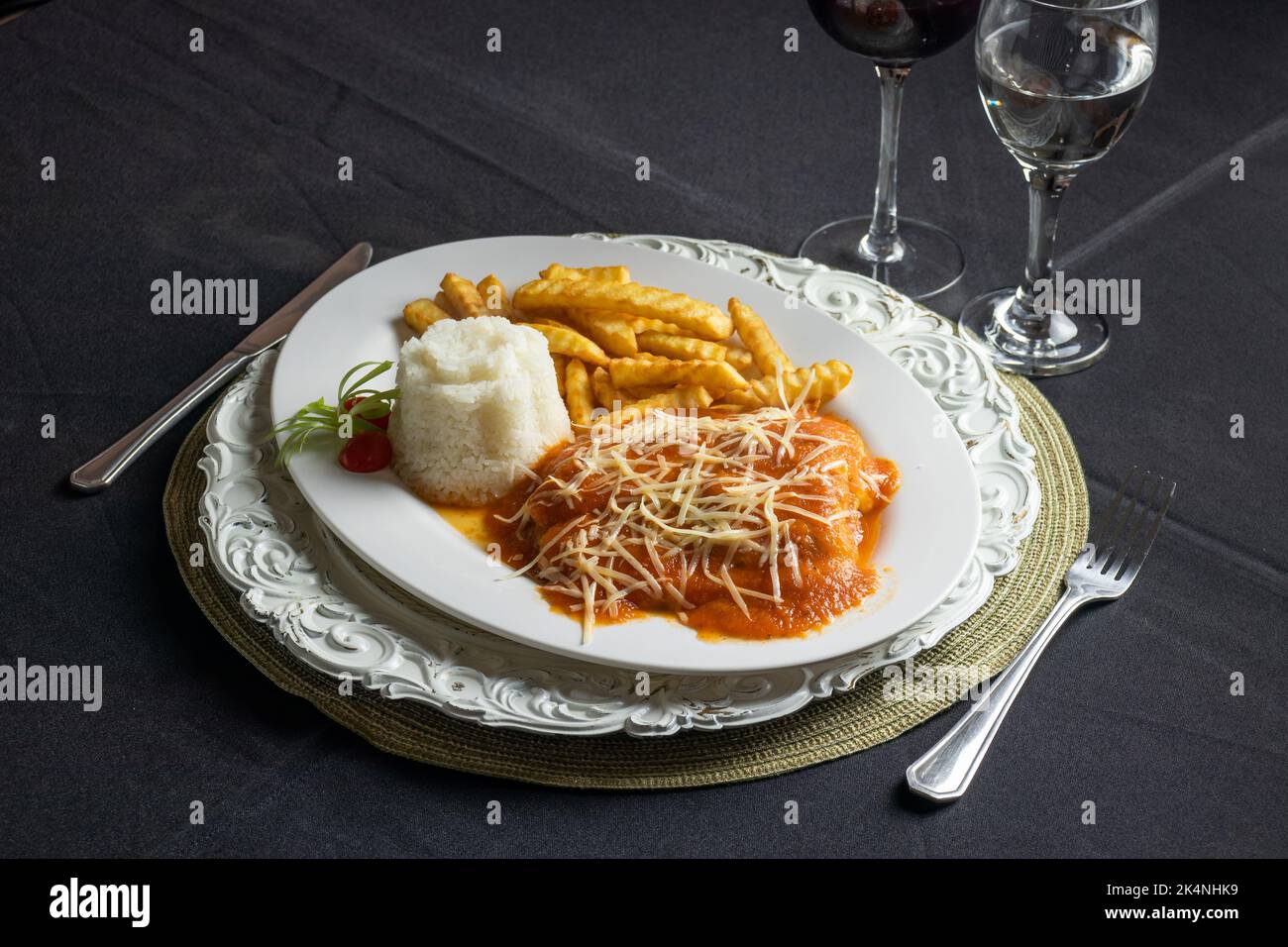 A close-up shot of a rice dish, french fries, and chicken fillet on a ...