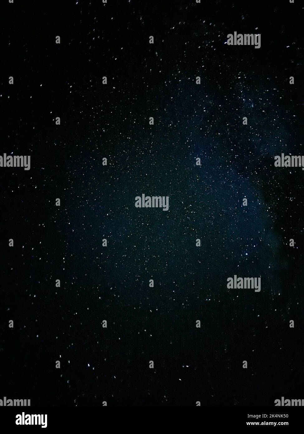 A vertical closeup of a night sky with green and blue patterns and ...
