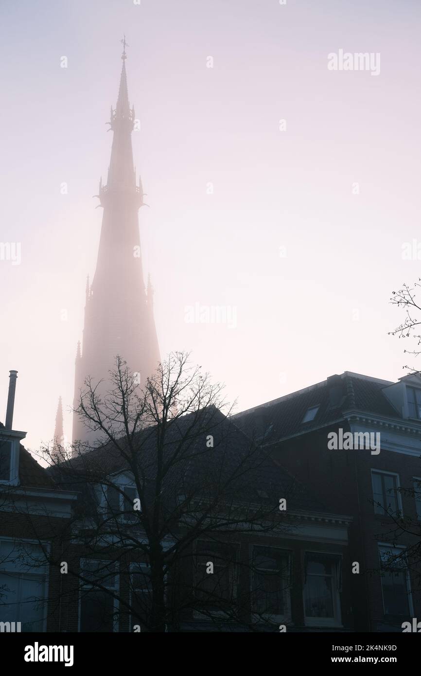 A vertical low-angle shot of foggy Saint Joseph chapel spire with ...