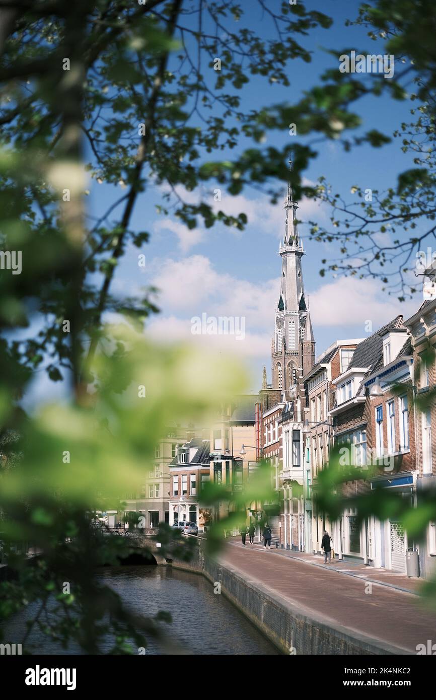 A vertical of The Old Delft with the tower and blue sky background ...