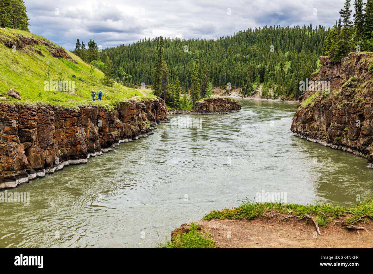 Tourists explore basalt rock formations; Miles Canyon; Whitehorse ...