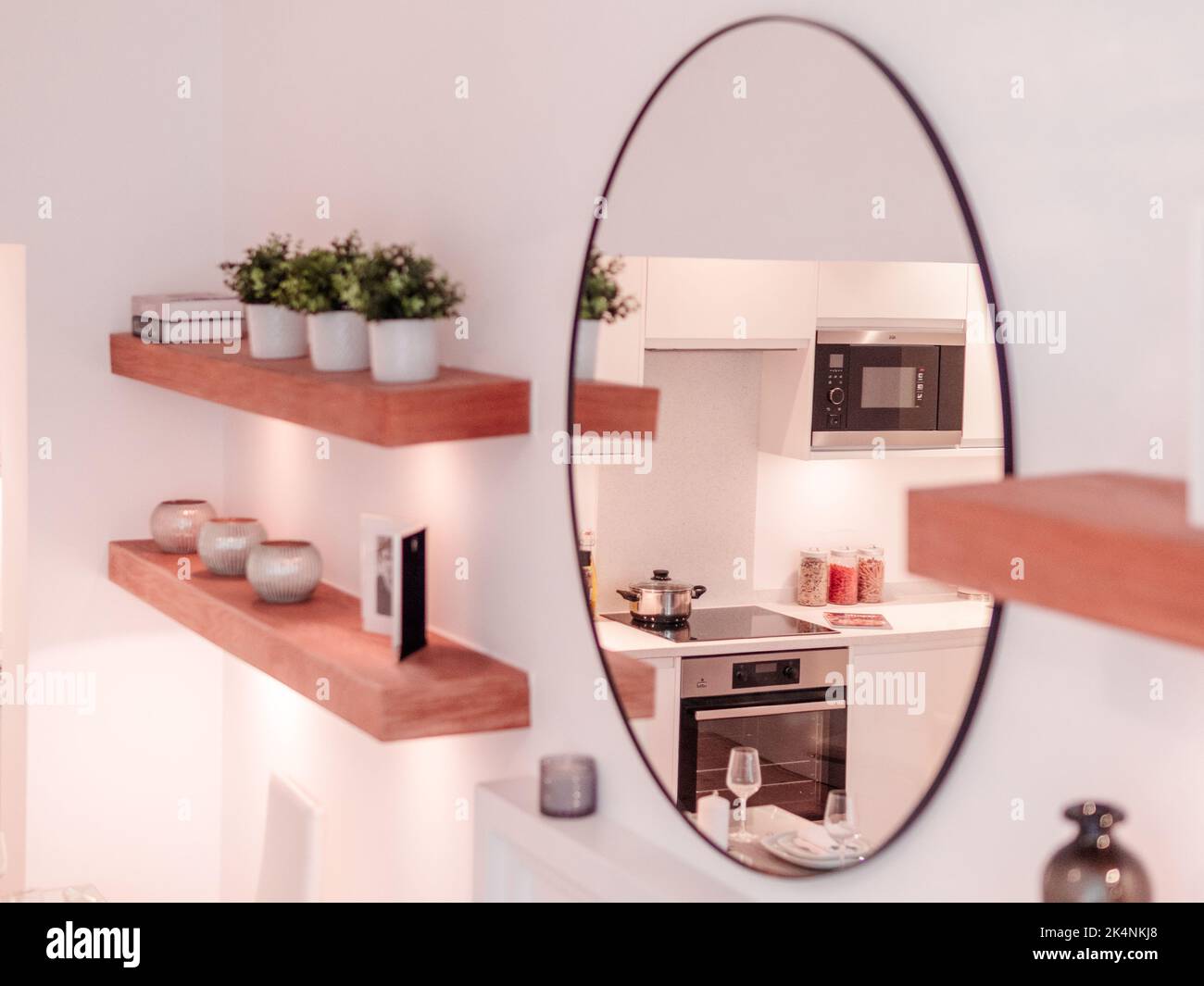A mirror on the white wall reflecting the interior of the kitchen Stock ...