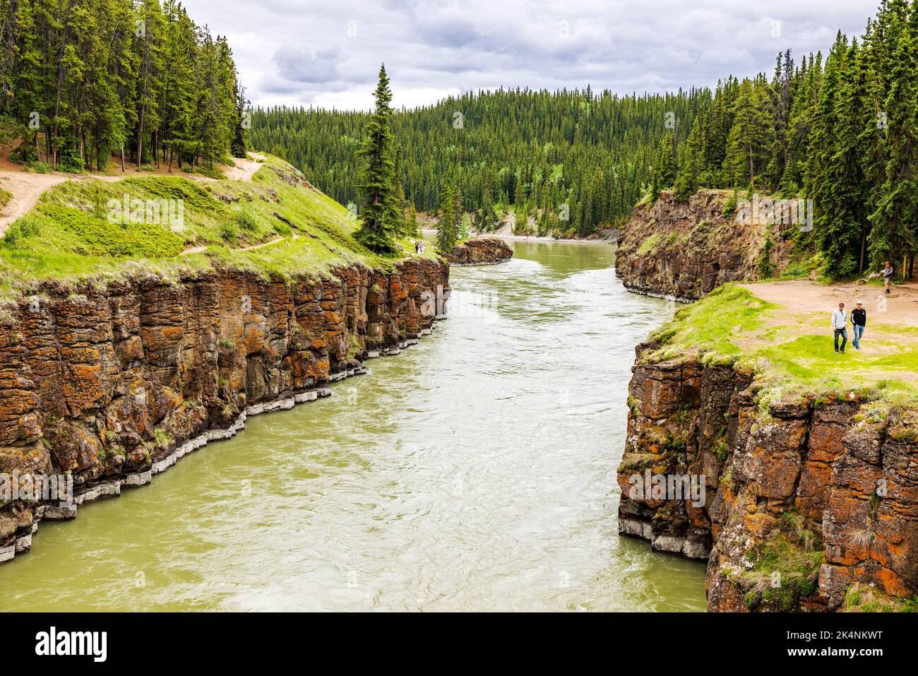 Tourists explore basalt rock formations; Miles Canyon; Whitehorse ...
